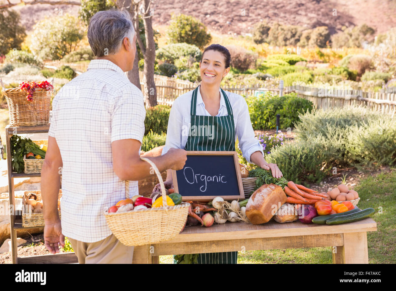 Smiling brunette farmer selling vegetables Stock Photo - Alamy