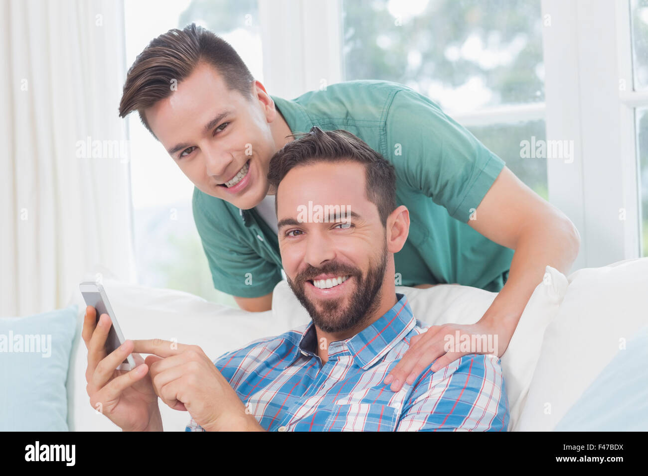 Cheerful gay couple looking phone hi-res stock photography and images ...