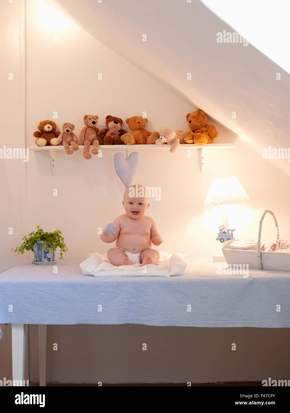 A baby sitting on a nursing table, Sweden Stock Photo - Alamy