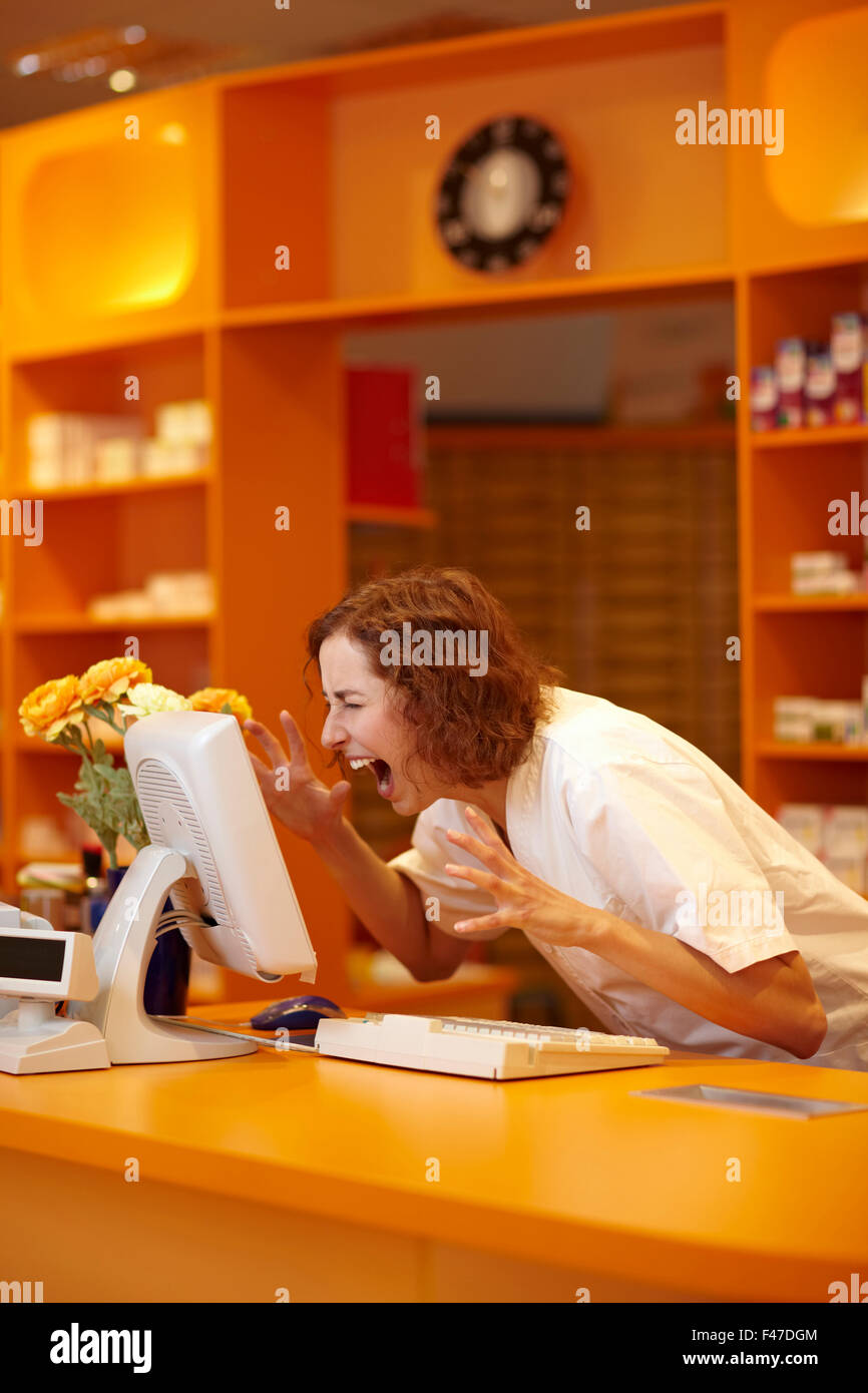 Female pharmacist screaming at computer on counter Stock Photo - Alamy