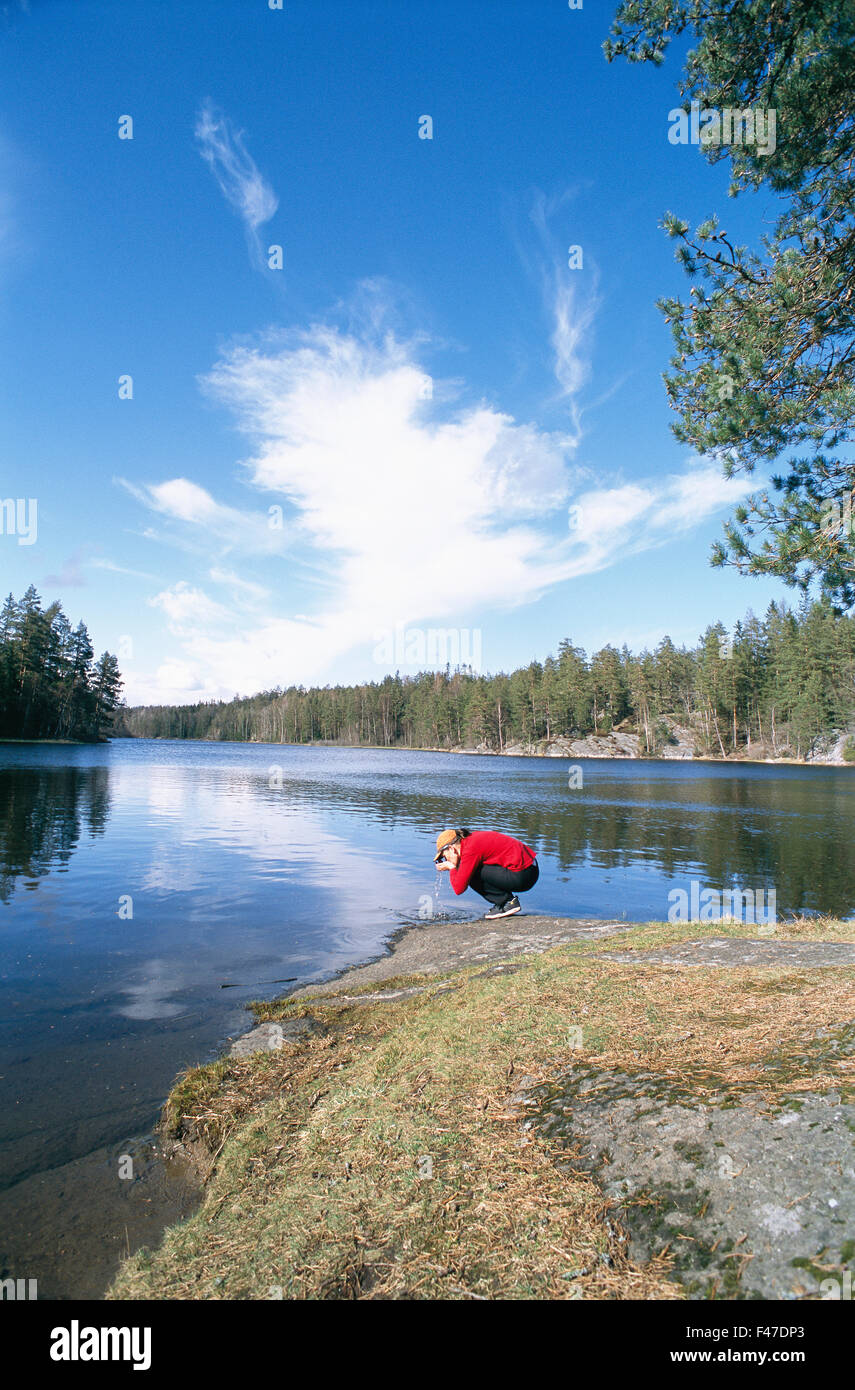 A woman drinking water from a lake, Sweden Stock Photo - Alamy