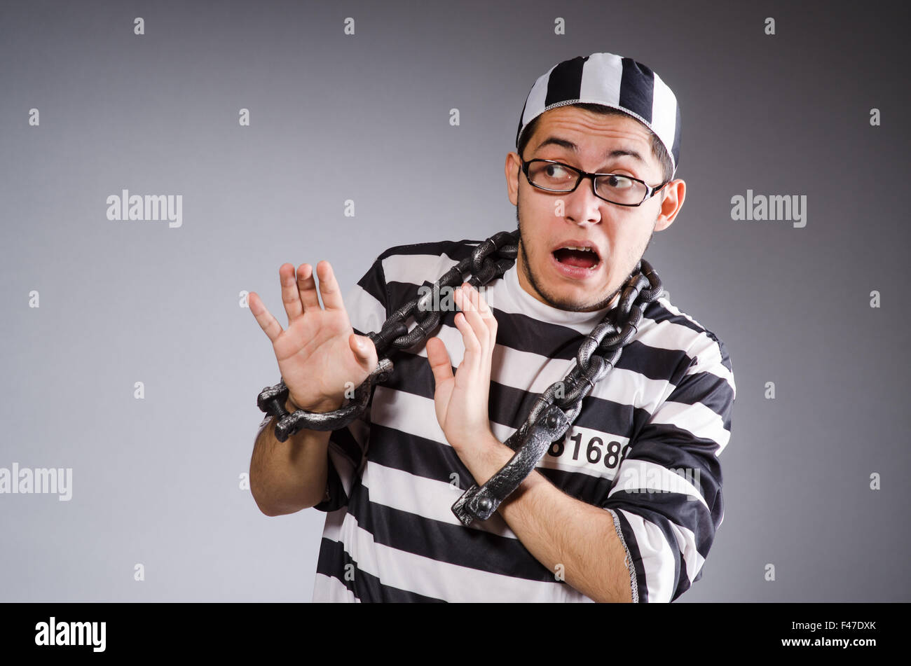 Funny prisoner in chains isolated on gray Stock Photo - Alamy