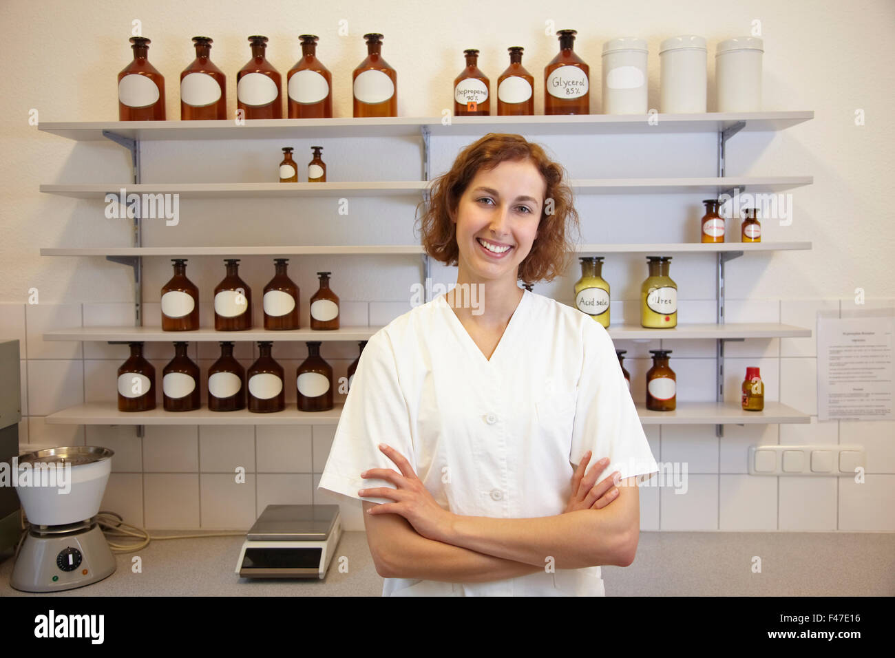Female pharmacist standing in lab with shelf Stock Photo - Alamy