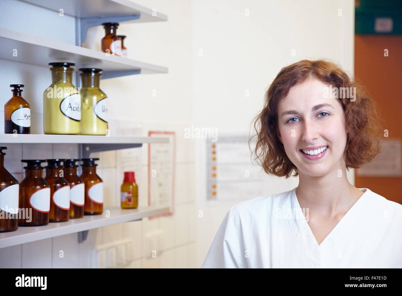 Happy female pharmacy technician in lab with shelf Stock Photo - Alamy