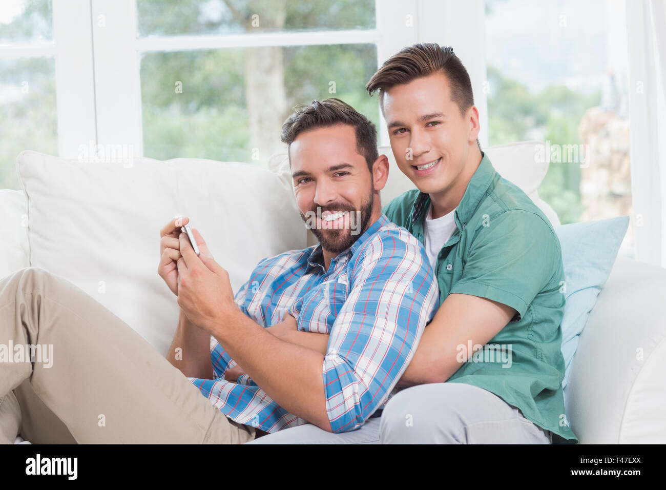 Handsome gay couple looking phone hi-res stock photography and images ...