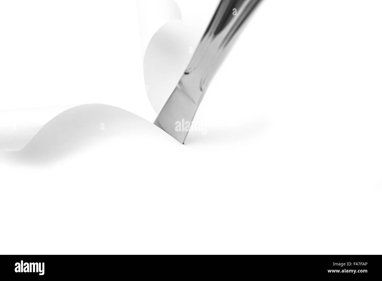 knife blade cuts white paper on a white background Stock Photo - Alamy