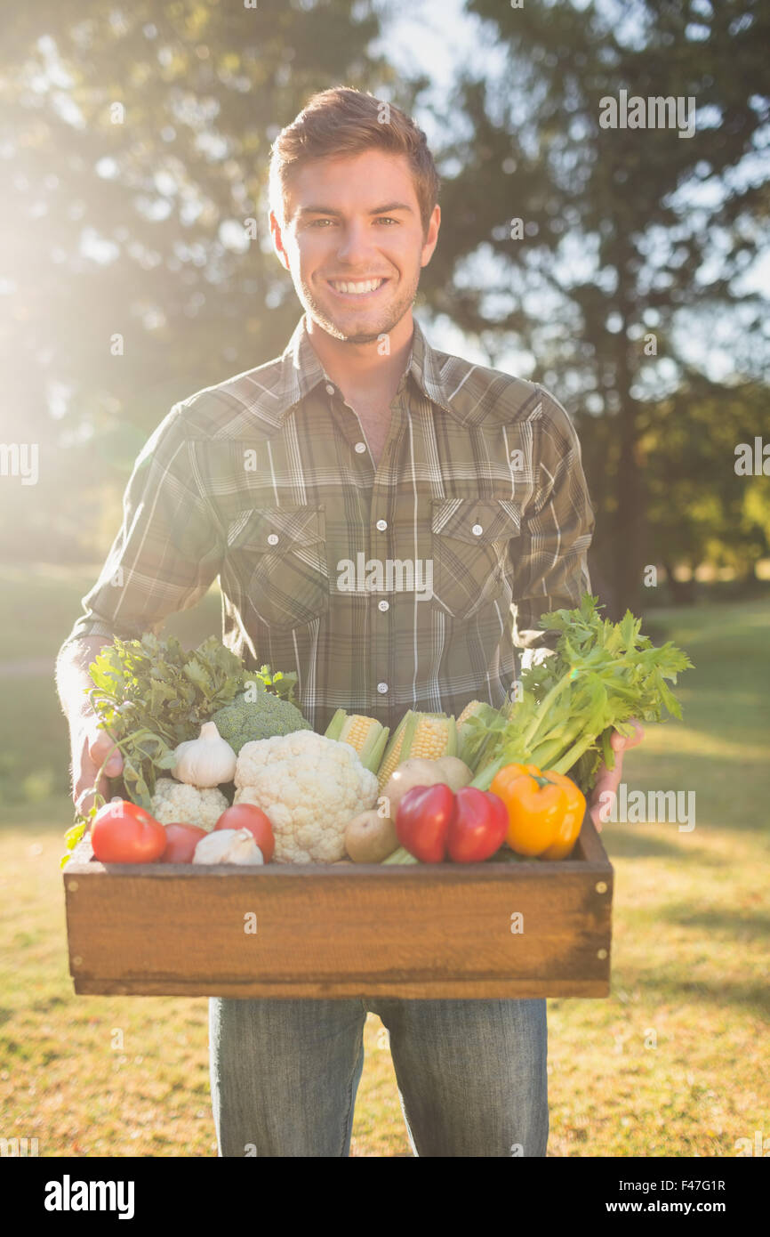 Smiling man carrying box of vegetables Stock Photo - Alamy