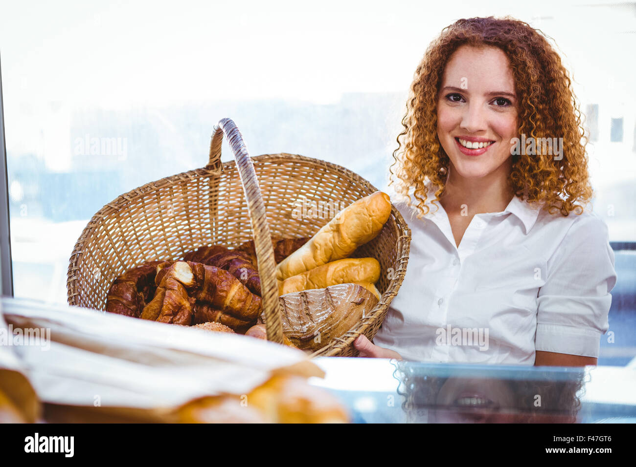 Pretty barista holding basket with bread Stock Photo - Alamy