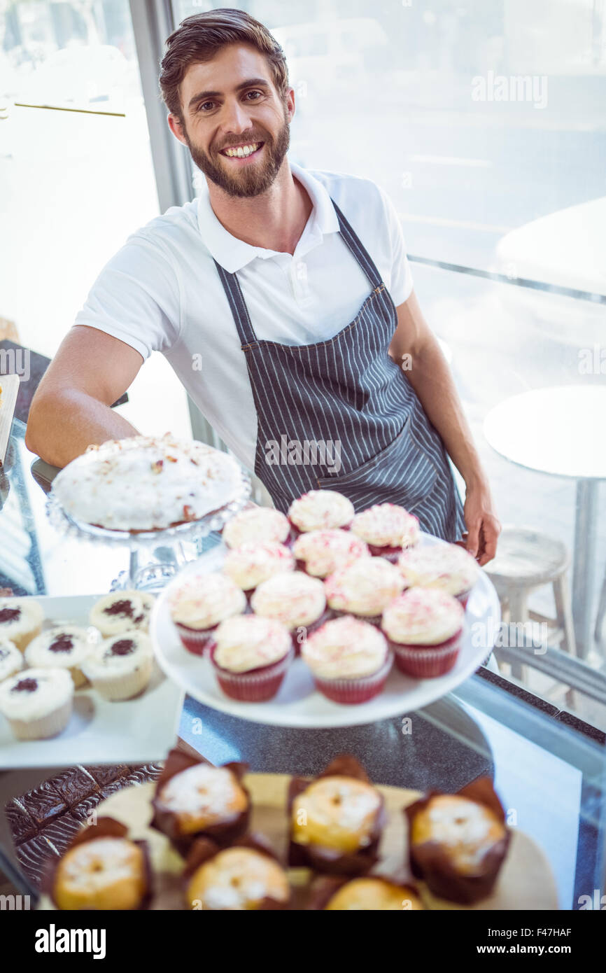Smiling worker posing behind the counter Stock Photo - Alamy