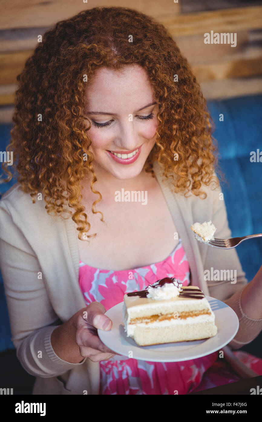 Smiling woman taking a piece of a cake Stock Photo - Alamy