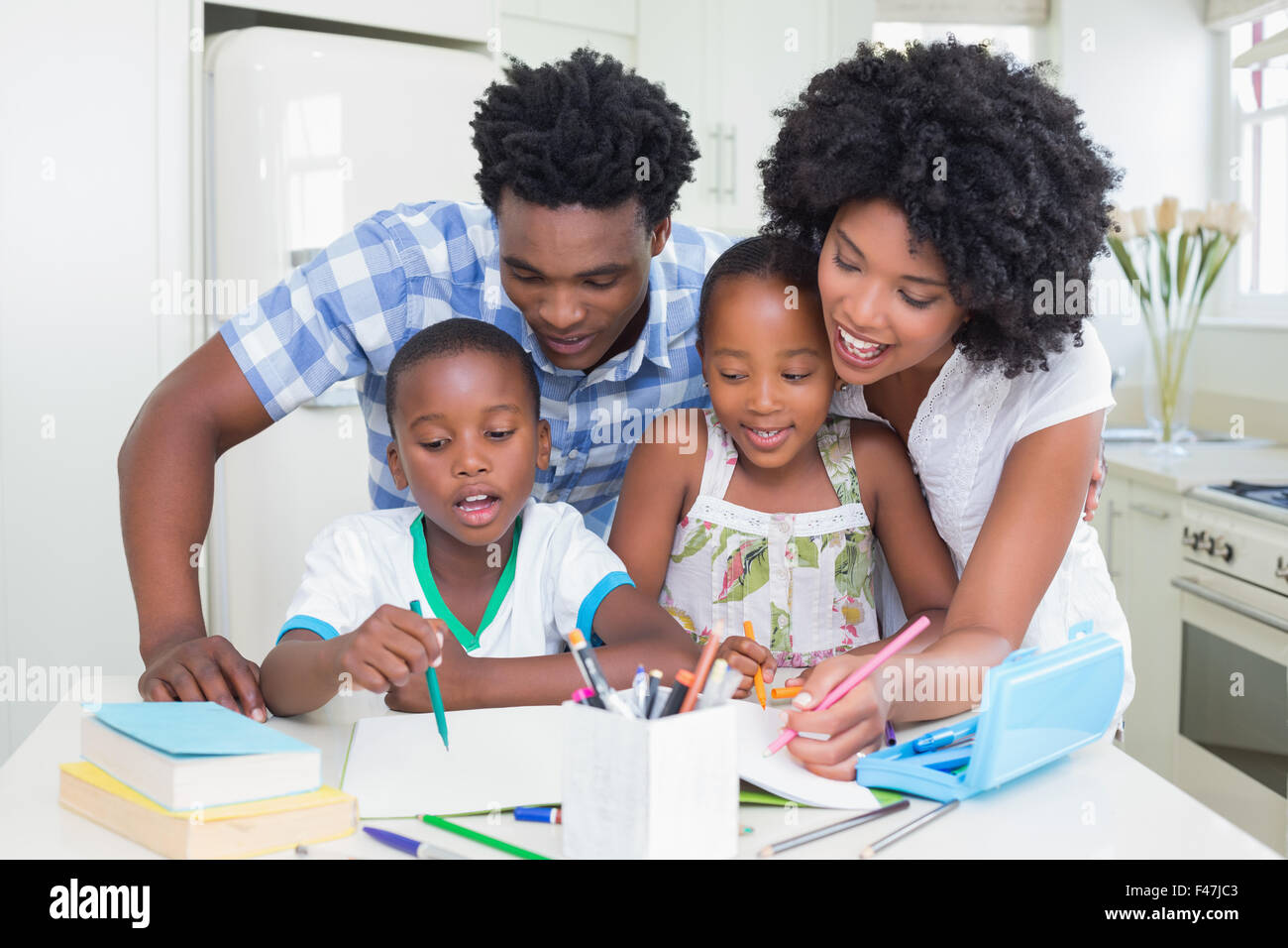 Happy parents helping children with homework Stock Photo - Alamy