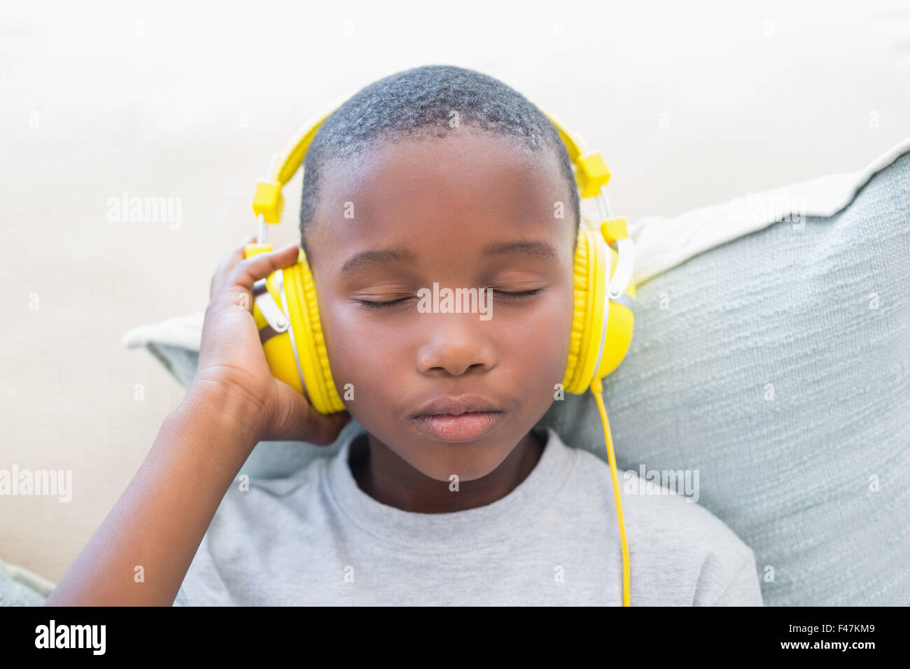 Little boy listening to music on the couch Stock Photo - Alamy