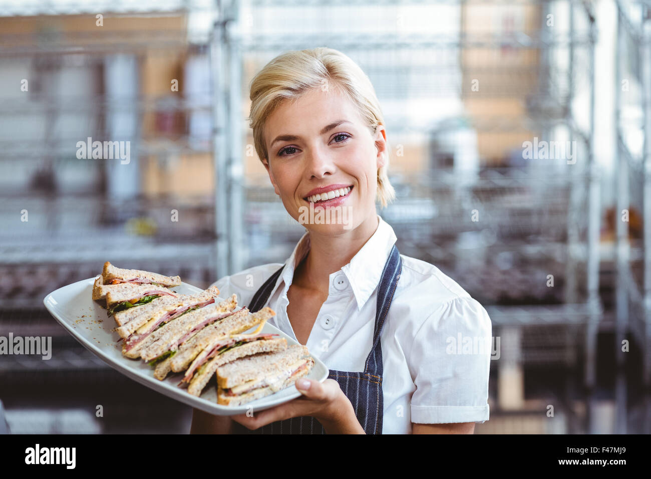 Selfassured female waitress smiling Stock Photo - Alamy