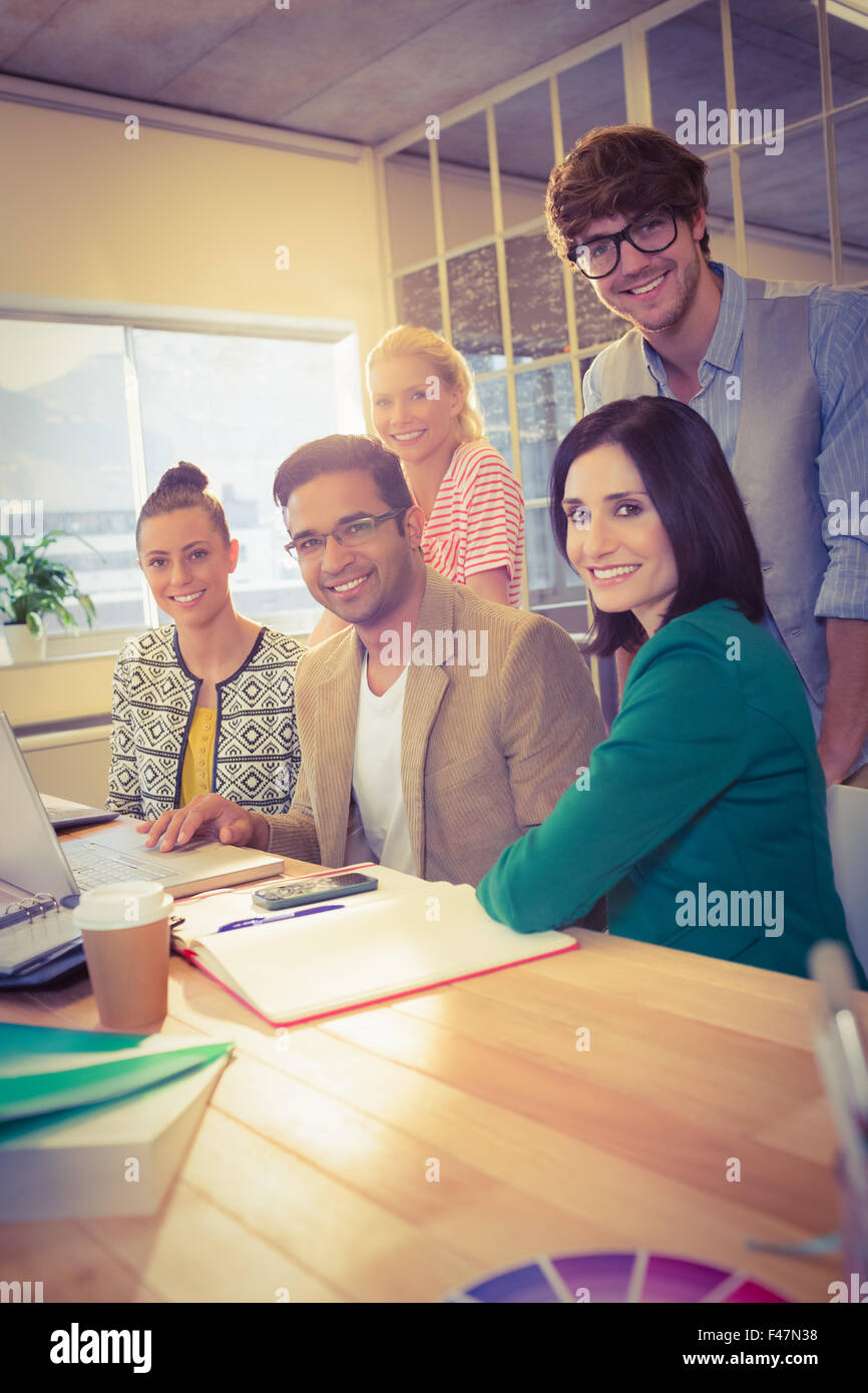 Happy colleagues using laptop in office Stock Photo - Alamy