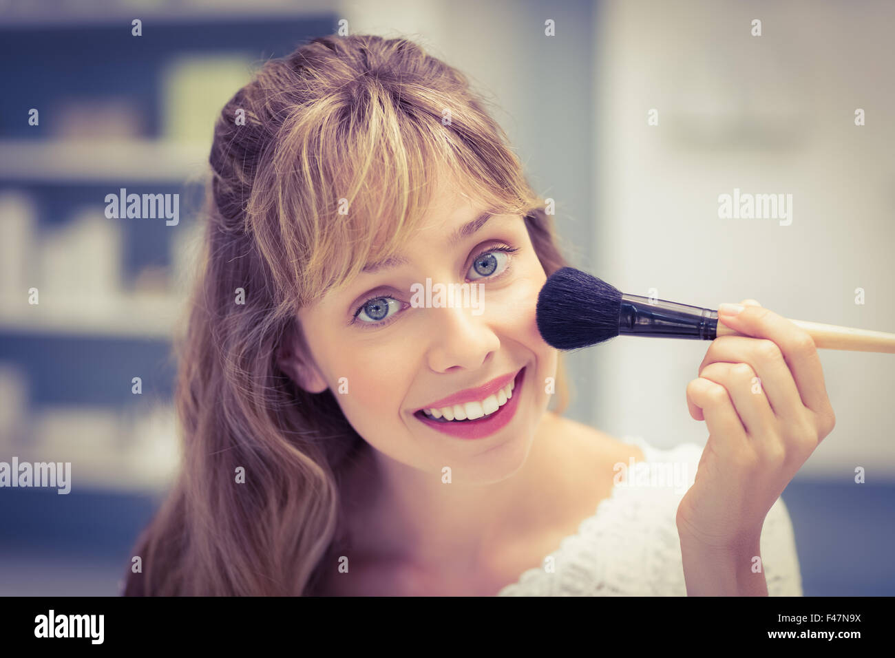 Beautiful costumer applying makeup Stock Photo - Alamy