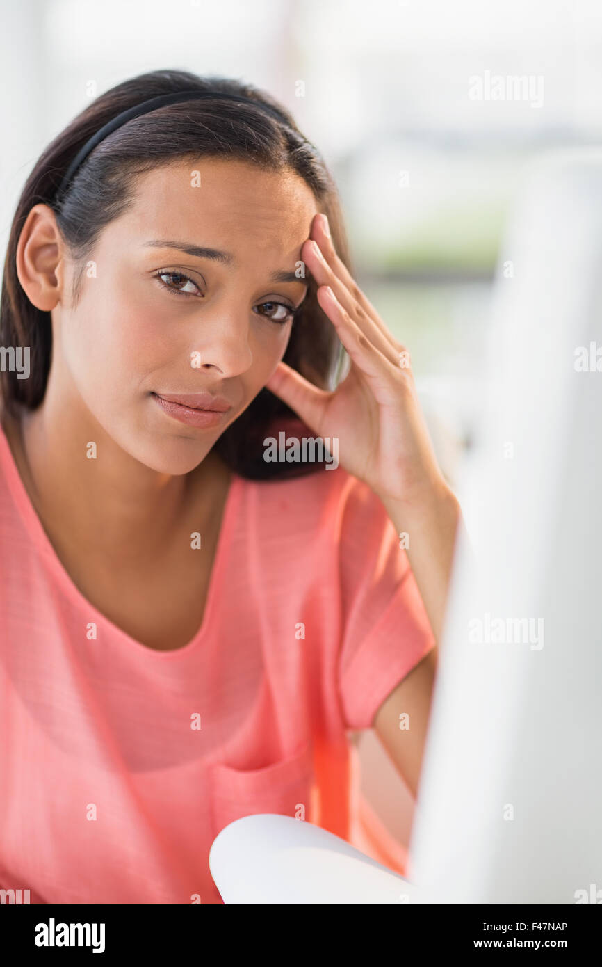 Creative businesswoman with hand on forehead looking at camera Stock ...