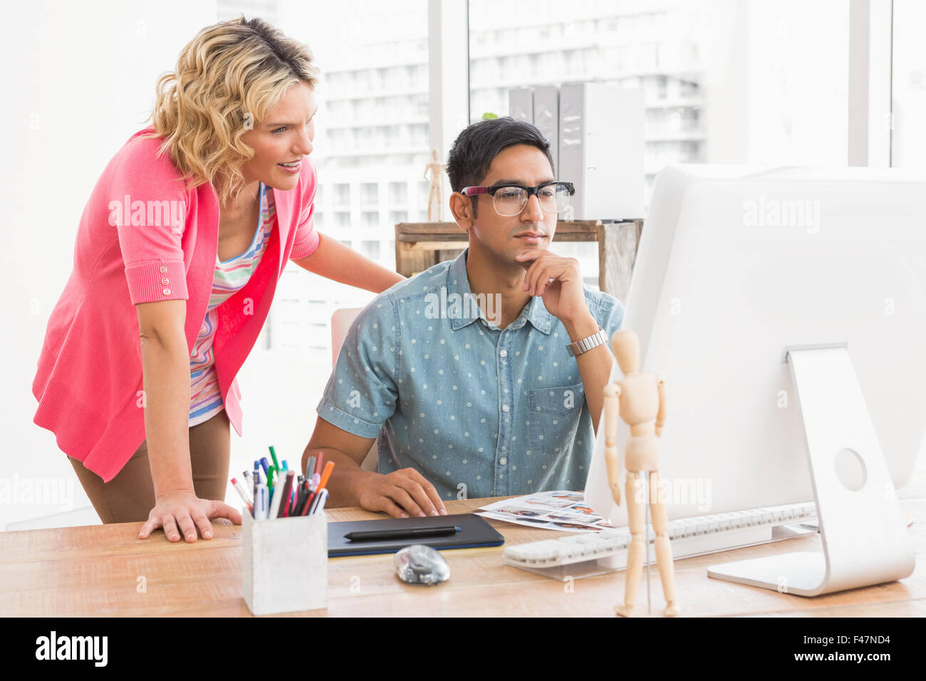 Colleagues using computer together Stock Photo - Alamy