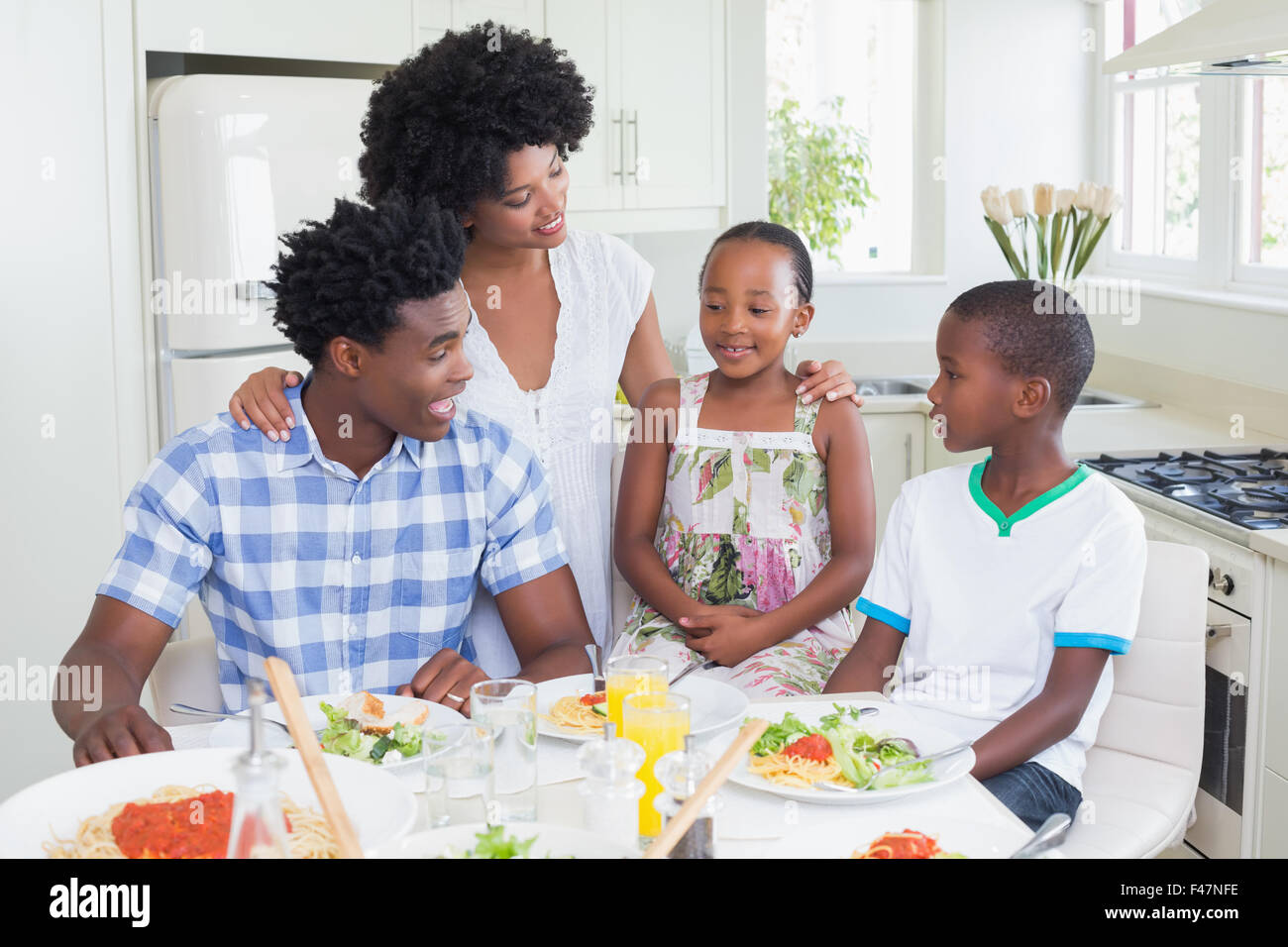 Happy family sitting down to dinner together Stock Photo - Alamy