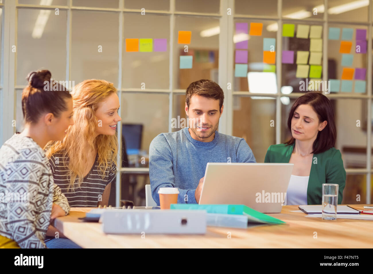 Group of young colleagues using laptop Stock Photo - Alamy