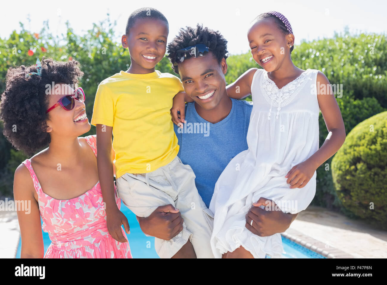 Happy family smiling at camera Stock Photo - Alamy