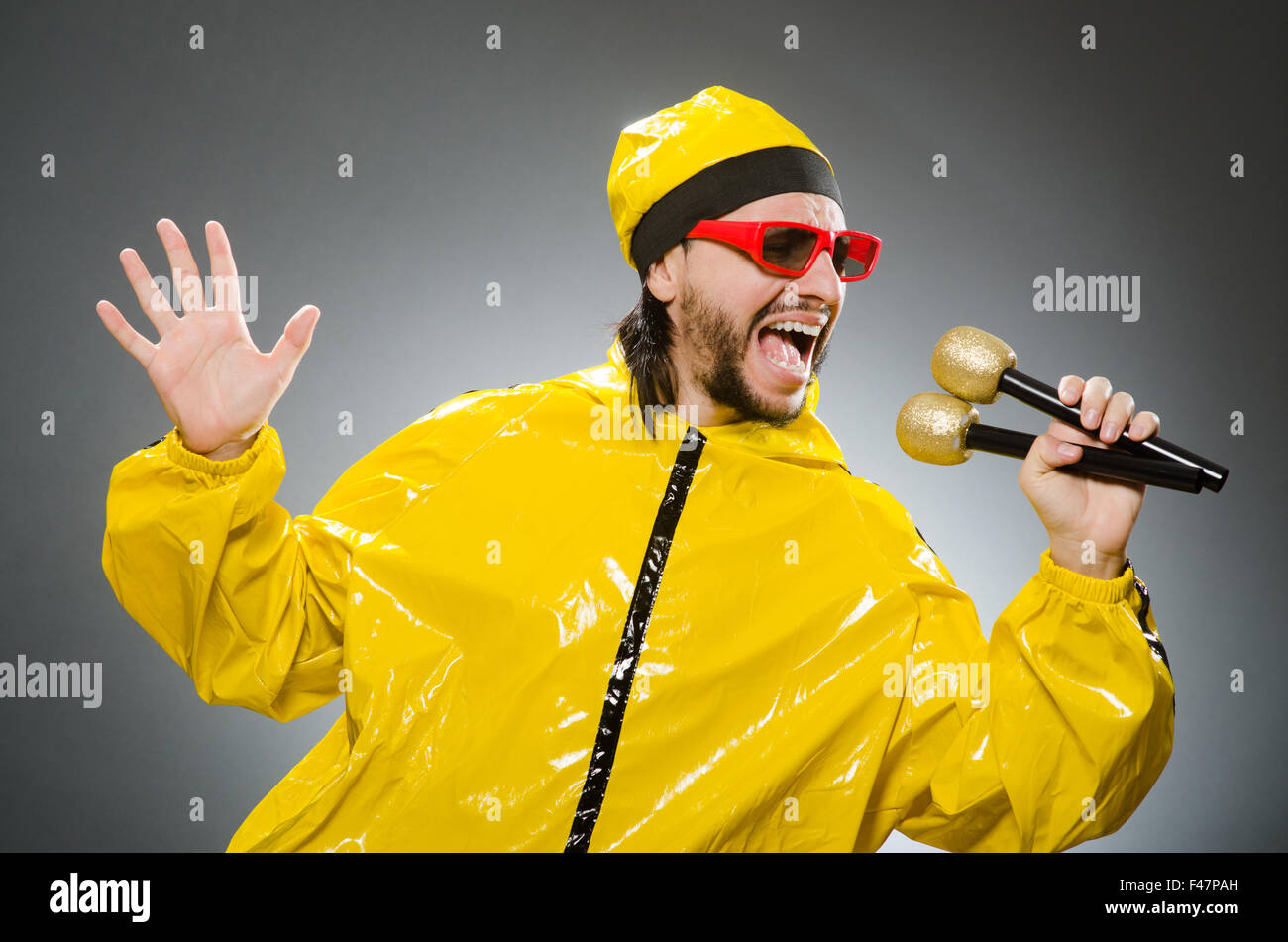 Man wearing yellow suit with mic Stock Photo - Alamy