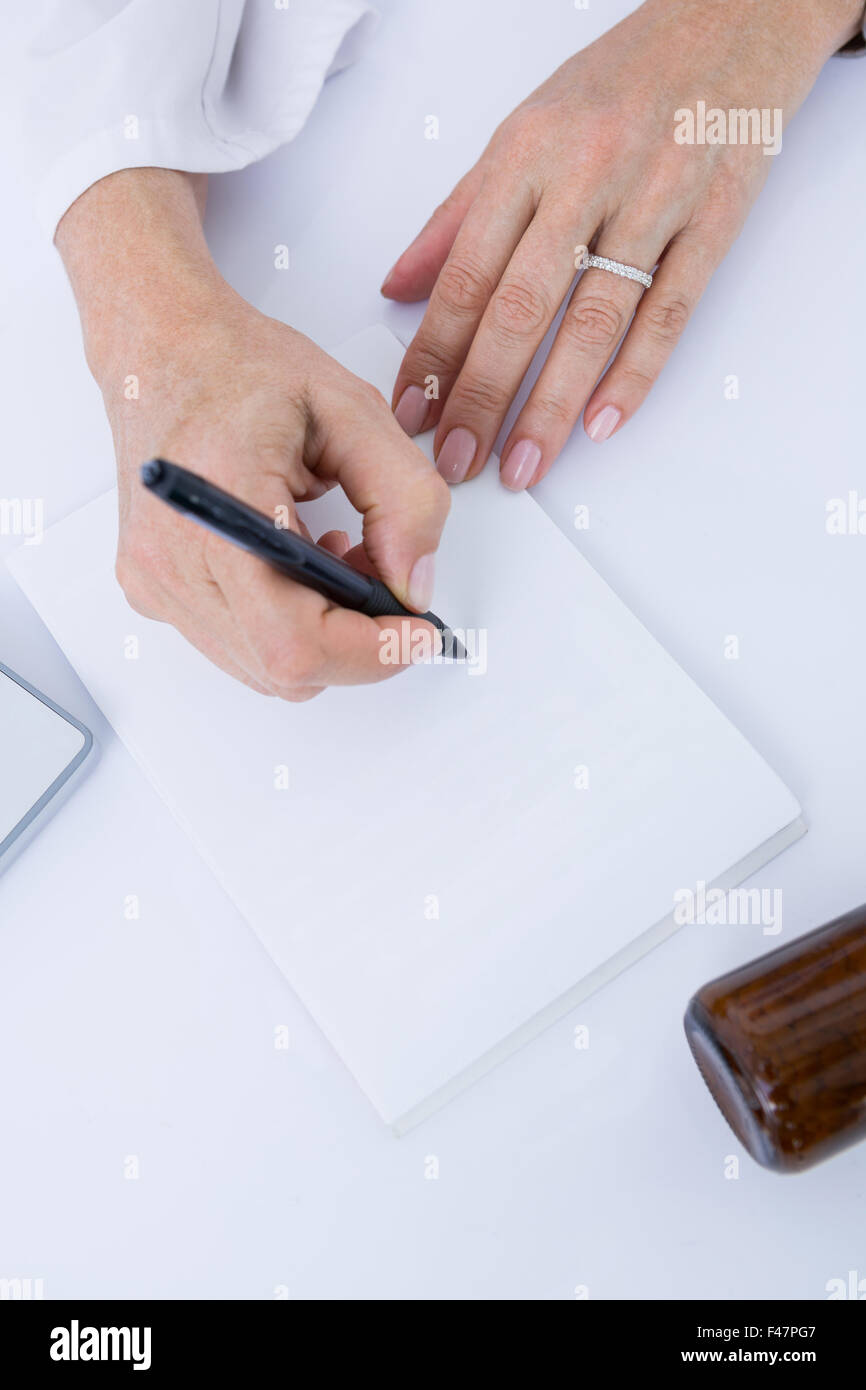 Doctor writing on a notepad Stock Photo - Alamy