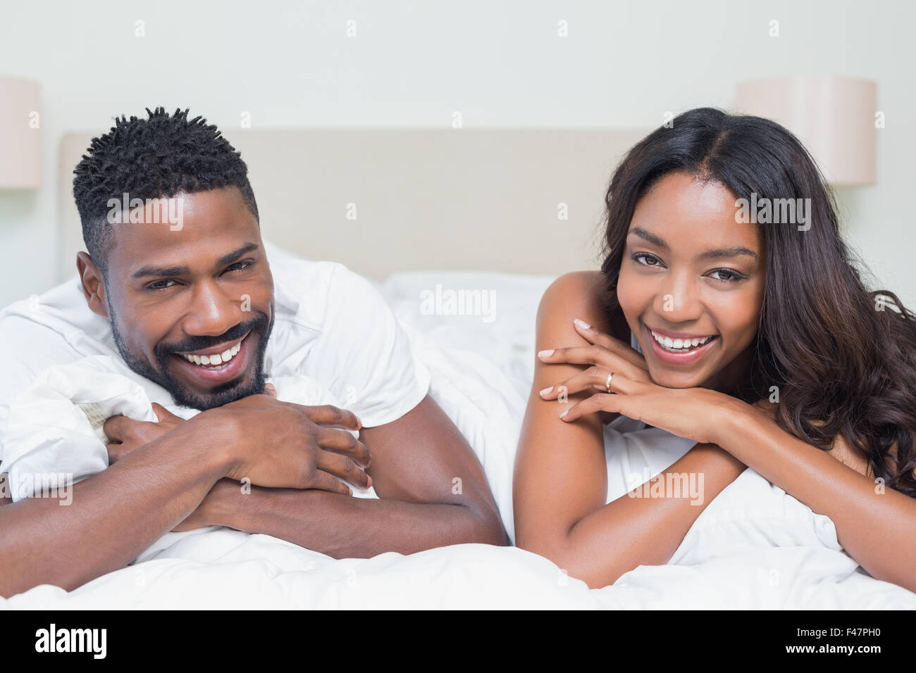 Happy couple on bed together Stock Photo - Alamy