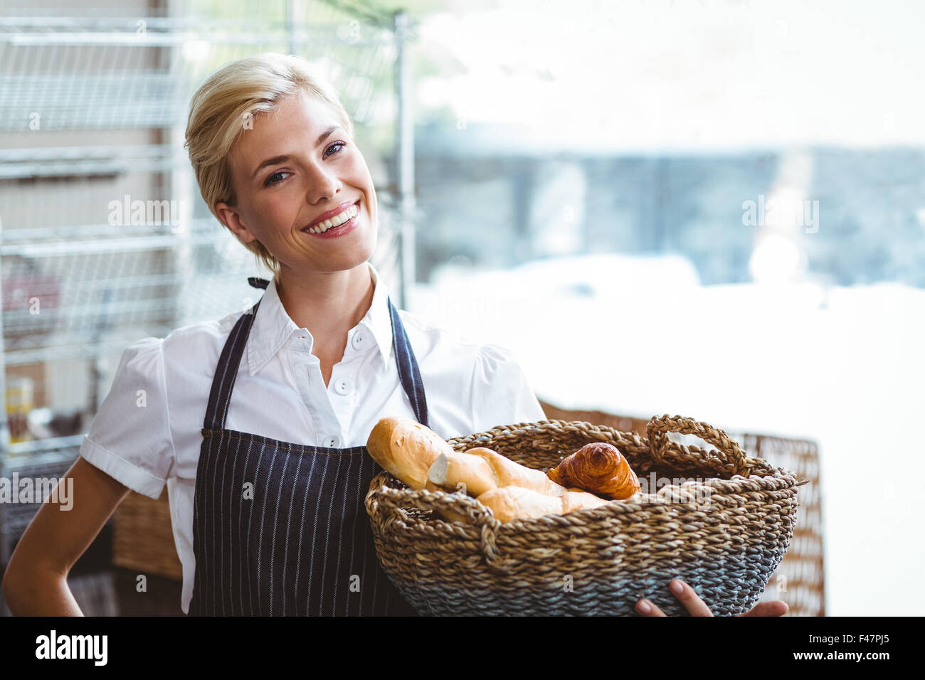Pretty waitress carrying basket of bread Stock Photo - Alamy