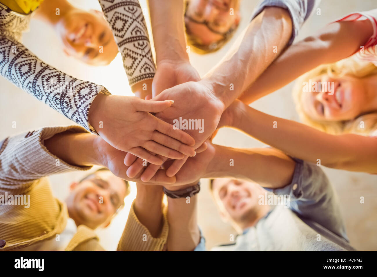 Happy business team joining their hands Stock Photo - Alamy