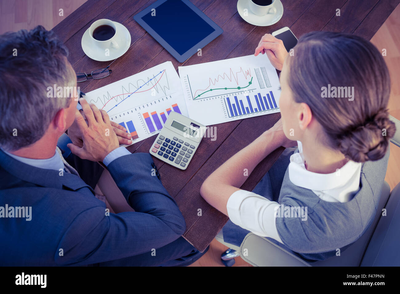 Business people looking at documents with graphics Stock Photo - Alamy