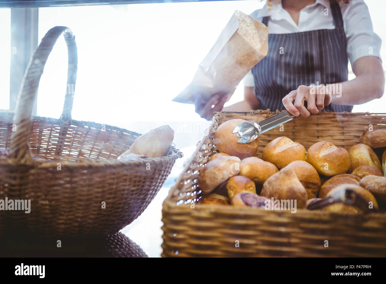 Barista putting pastry in paper bag Stock Photo - Alamy