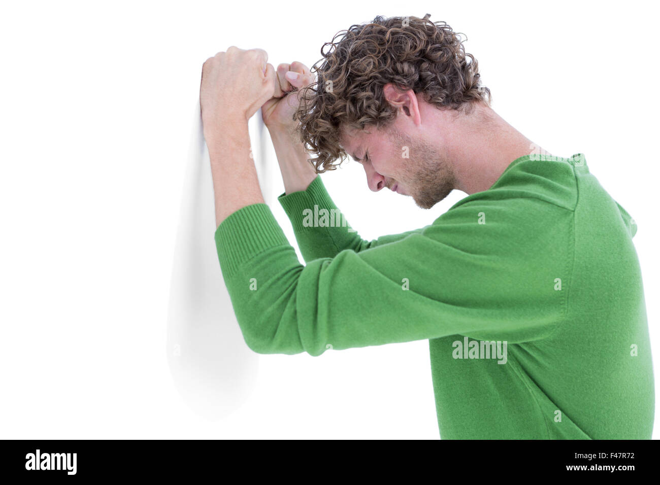 Sad casual man leaning against wall Stock Photo - Alamy