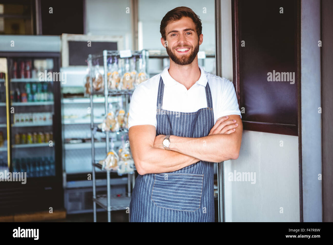 Smiling server in apron arm crossed Stock Photo - Alamy