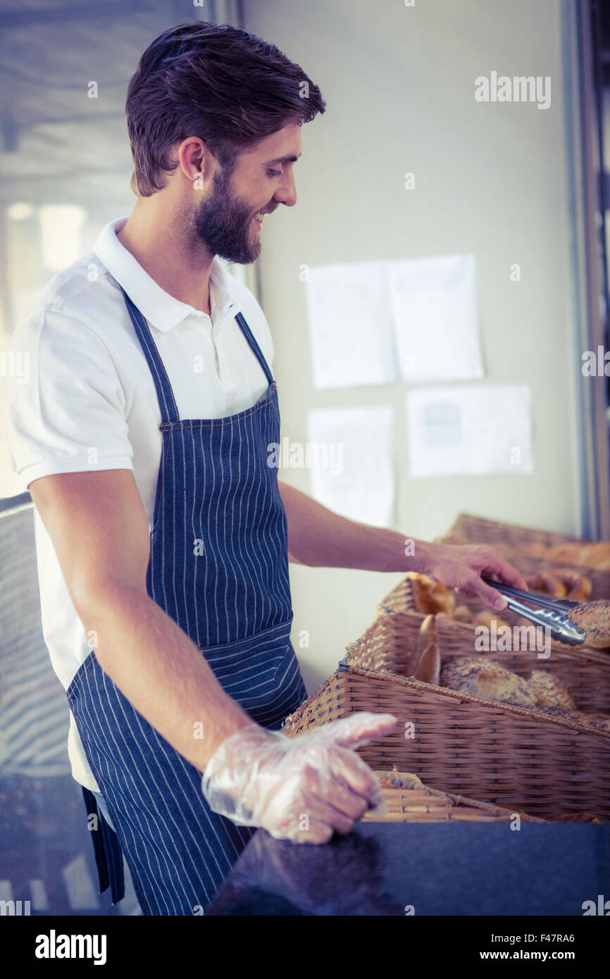 Smiling waiter taking bread with tongs Stock Photo - Alamy