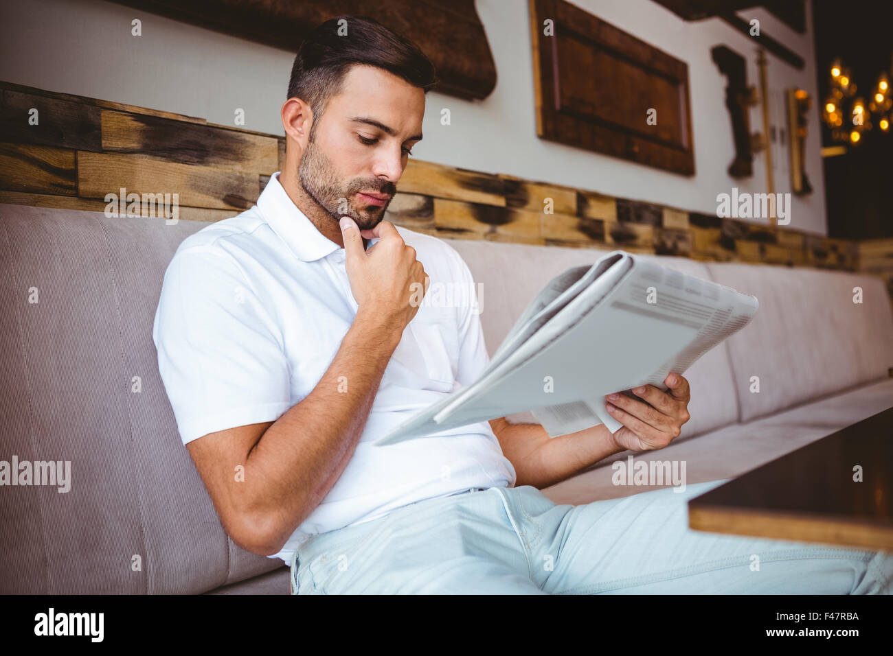 Young man reading a newspaper Stock Photo - Alamy