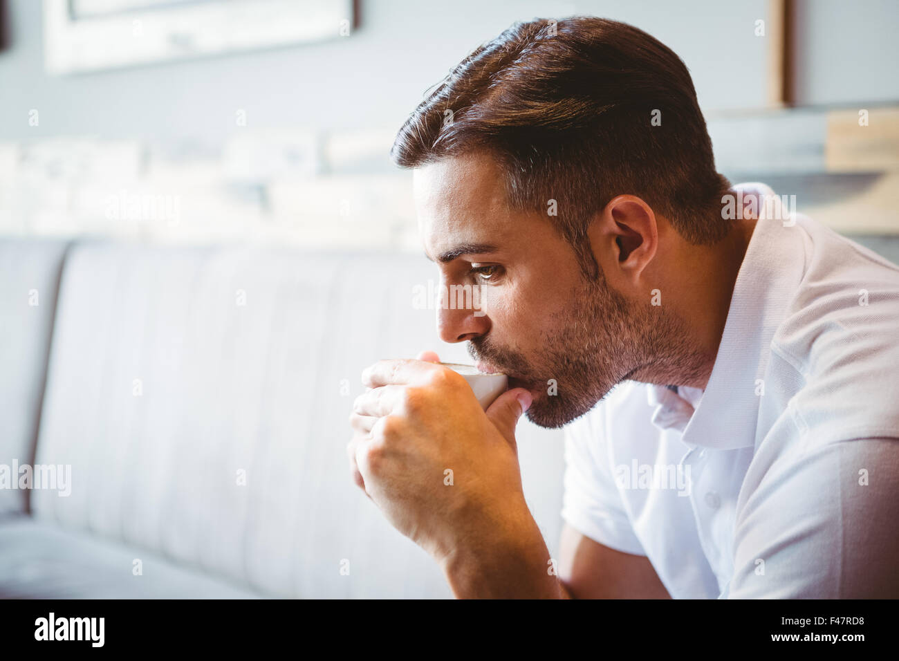 Young man drinking cup of coffee Stock Photo - Alamy