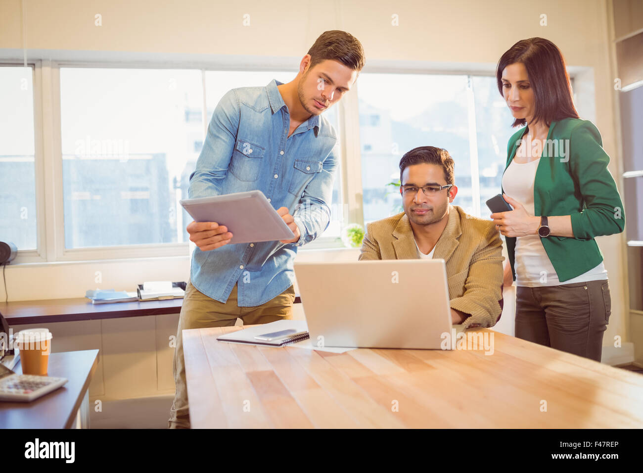 Colleagues using laptop in office Stock Photo - Alamy