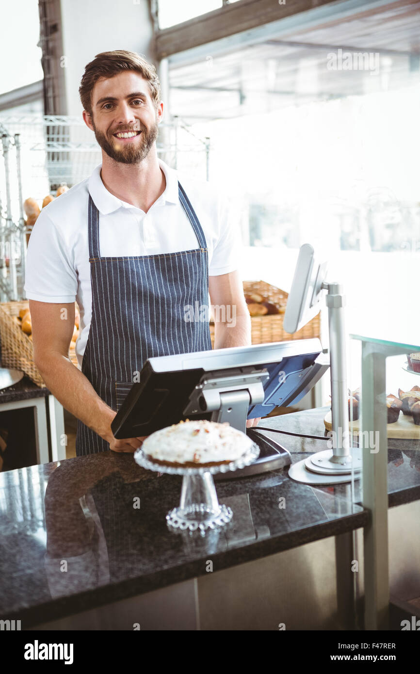 Smiling worker posing behind the counter Stock Photo - Alamy
