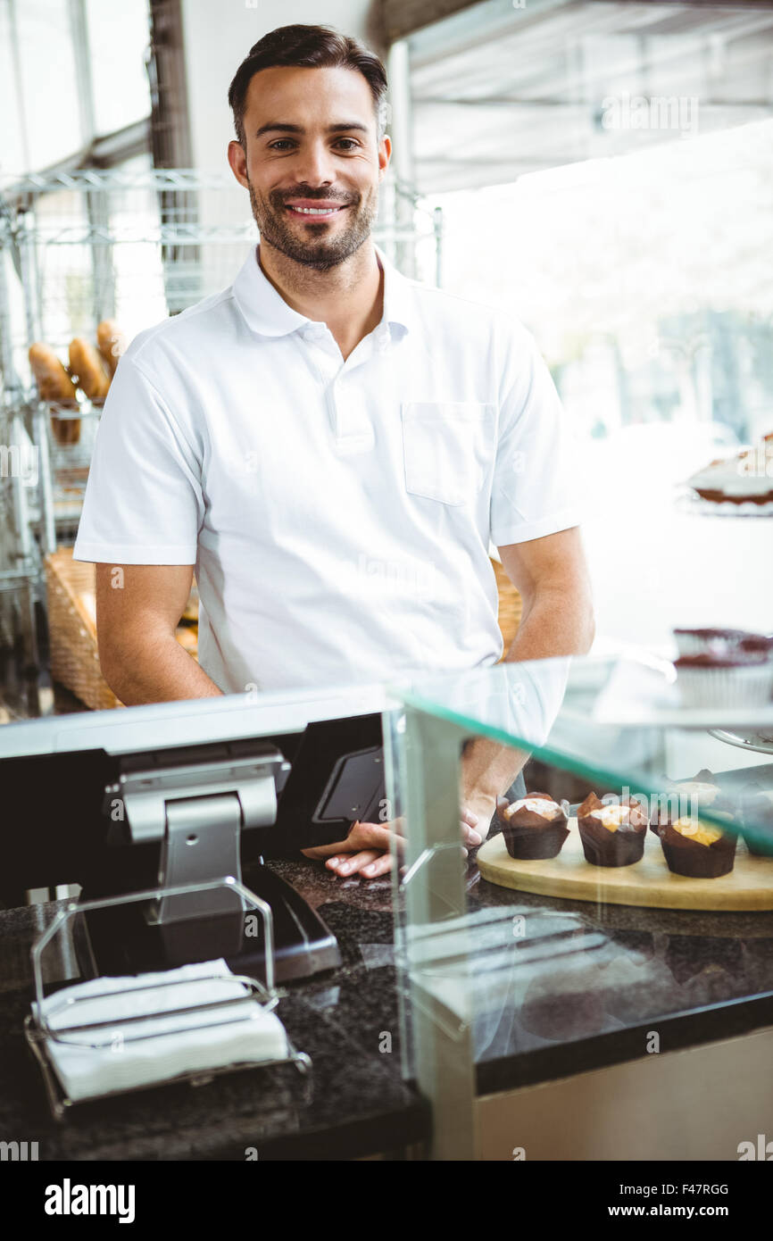 Smiling worker posing behind the counter Stock Photo - Alamy
