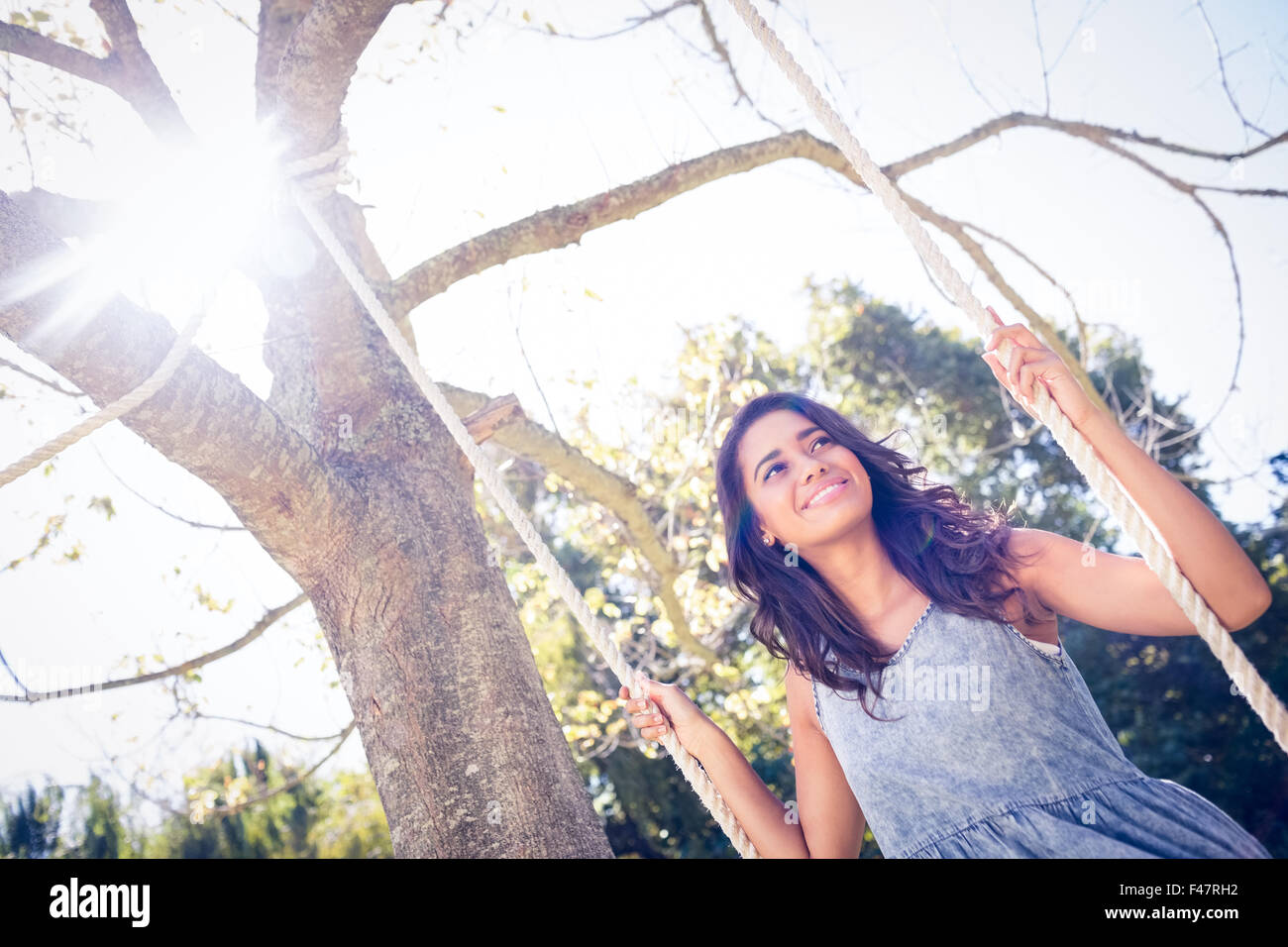 Pretty brunette swinging in park Stock Photo - Alamy