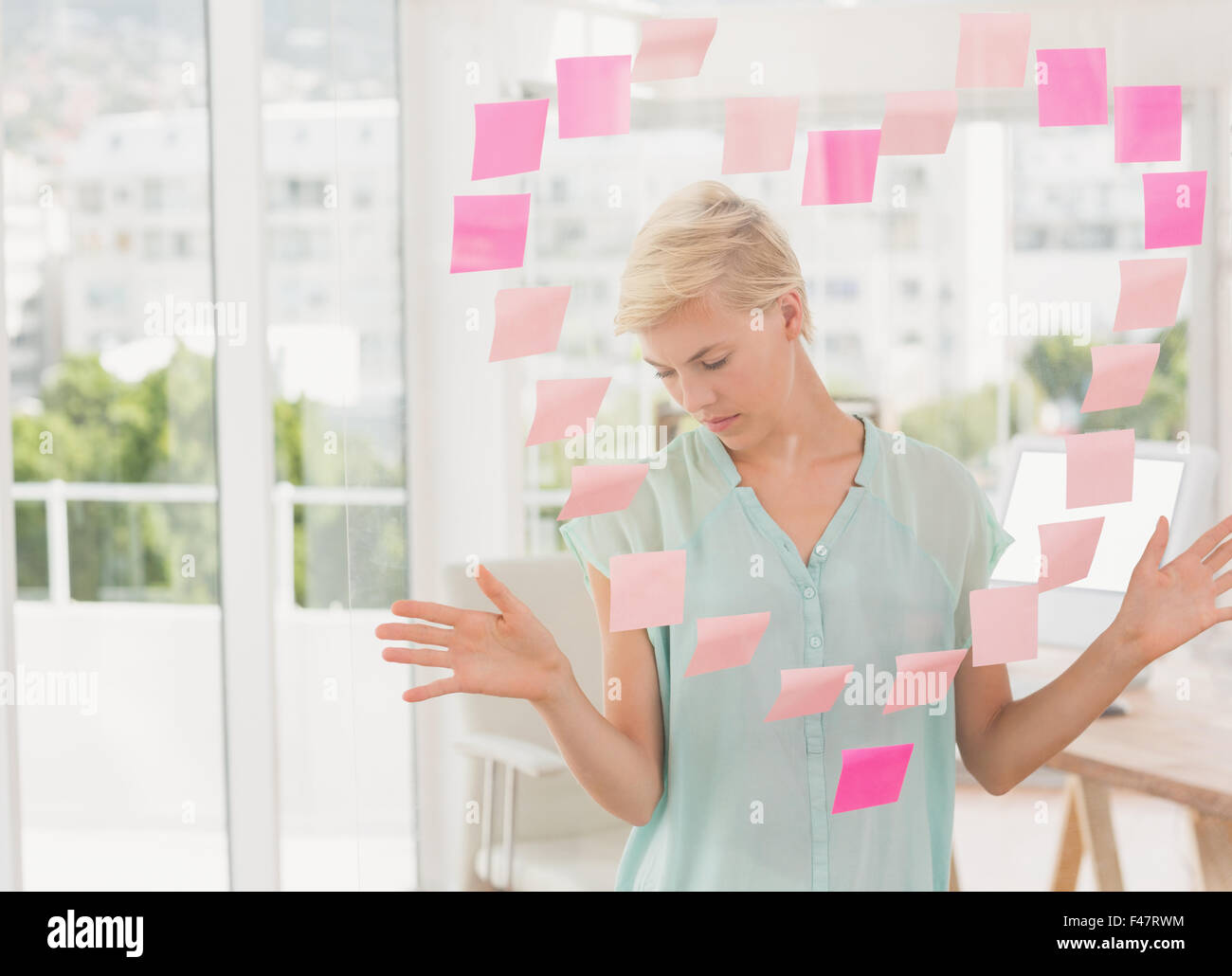 Sad creative businesswoman alone against glass wall Stock Photo - Alamy