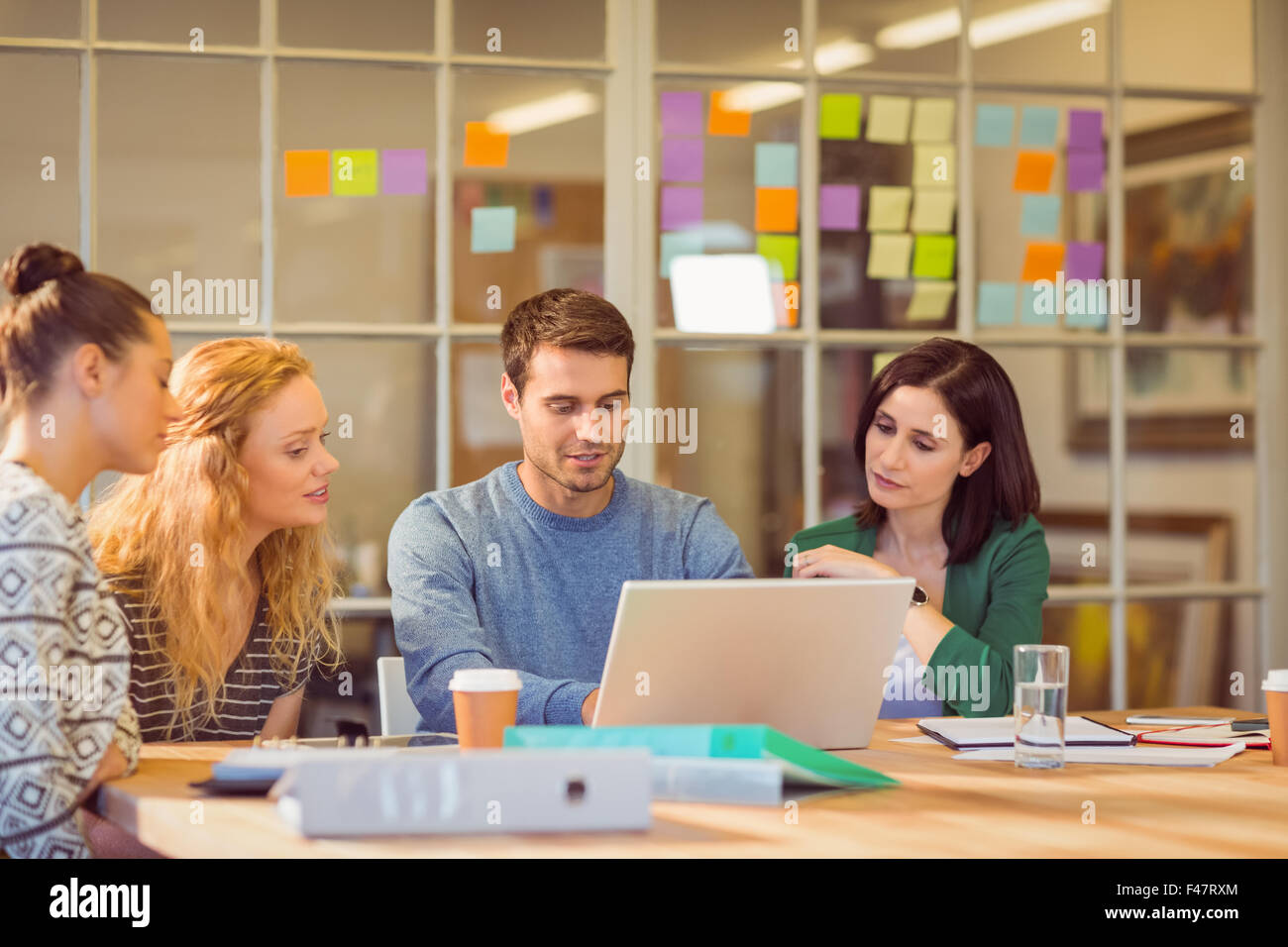 Group of young colleagues using laptop Stock Photo - Alamy