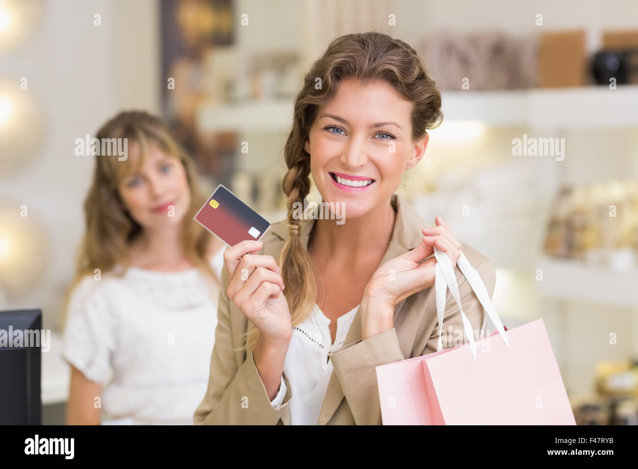 Beautiful customer at cash register holding credit card Stock Photo - Alamy