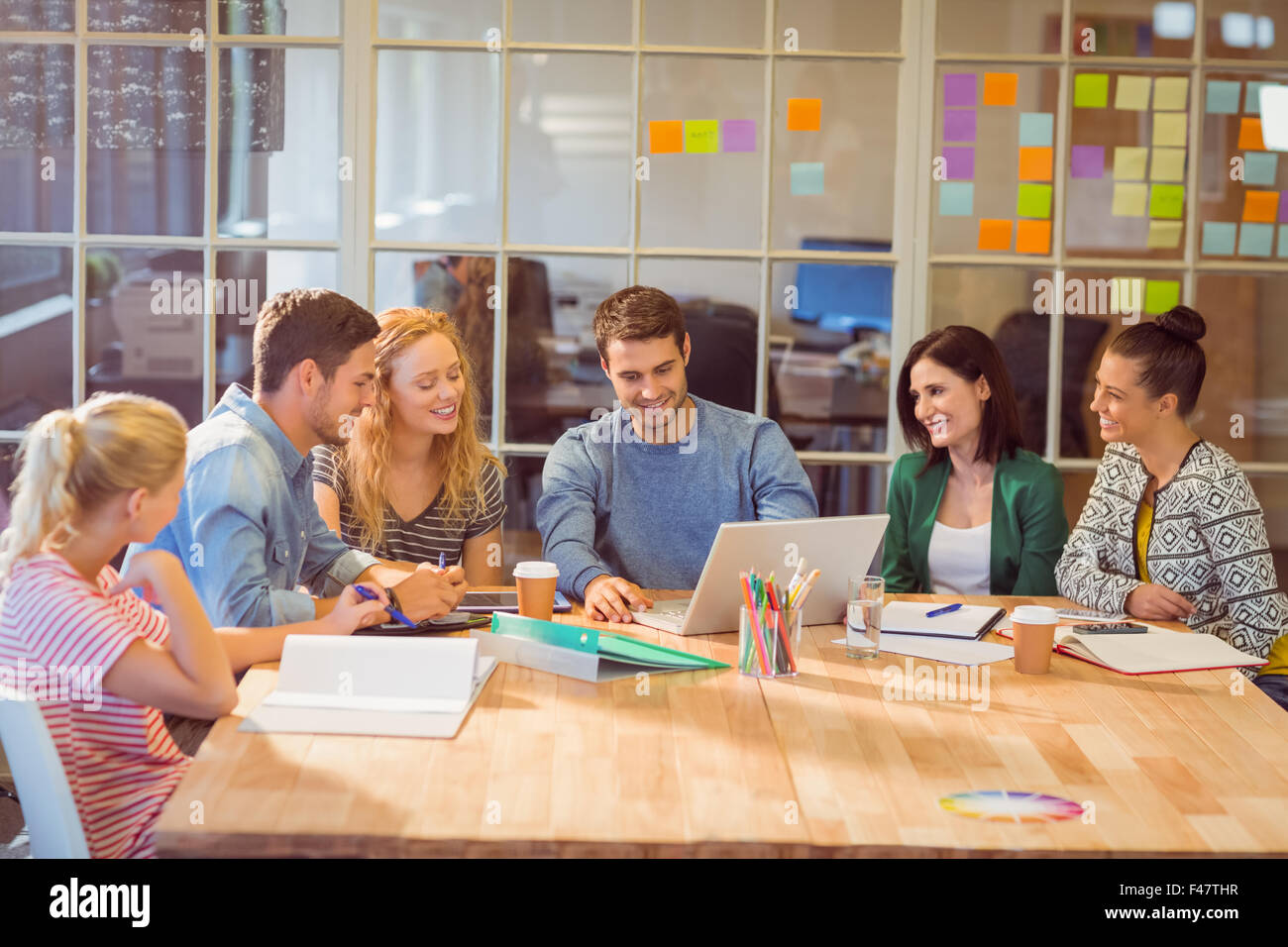 Group of young colleagues using laptop Stock Photo - Alamy
