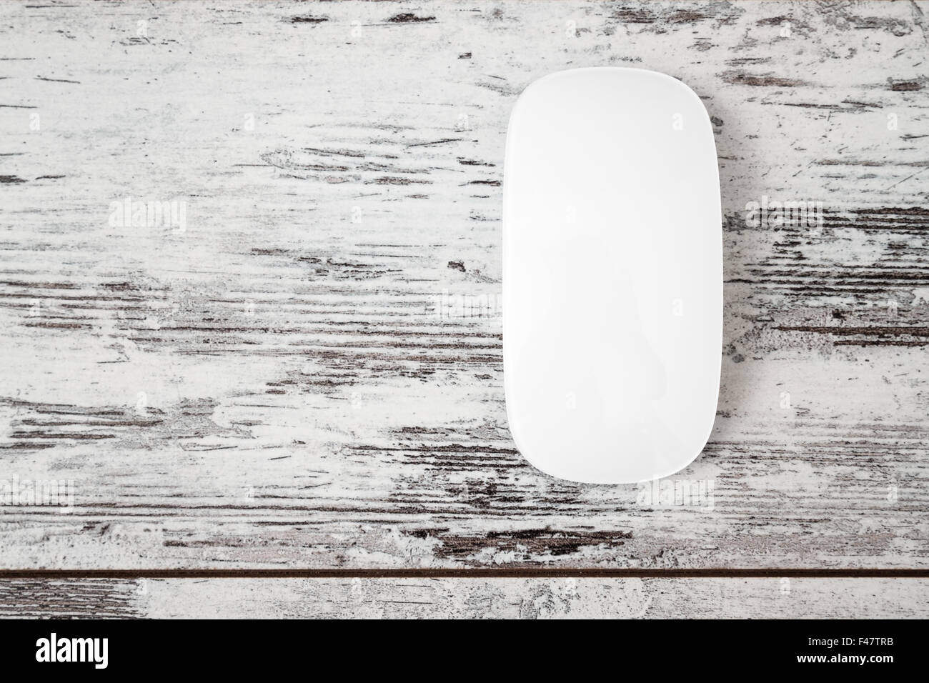 Wireless white modern computer mouse on white wooden background with ...