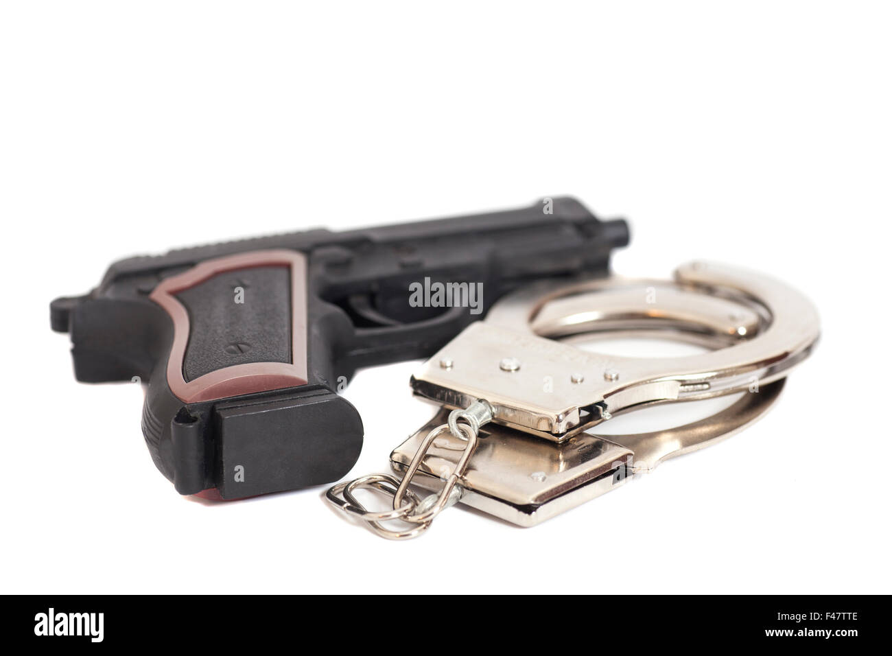 Gun and handcuffs isolated on white background Stock Photo - Alamy