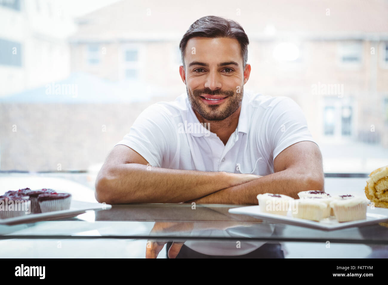 Smiling worker posing behind the counter Stock Photo - Alamy
