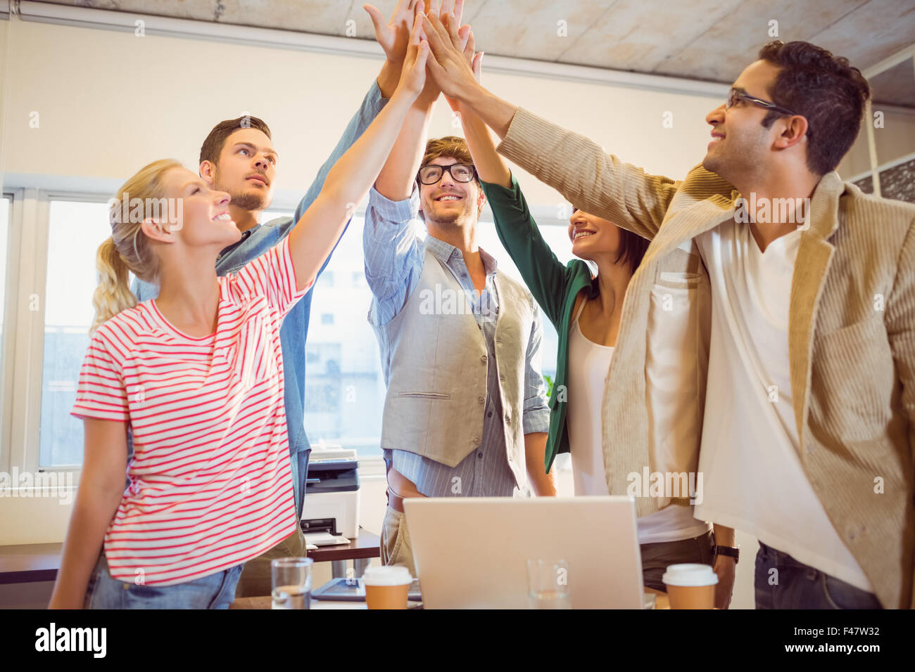 Happy business team doing hands checks Stock Photo - Alamy