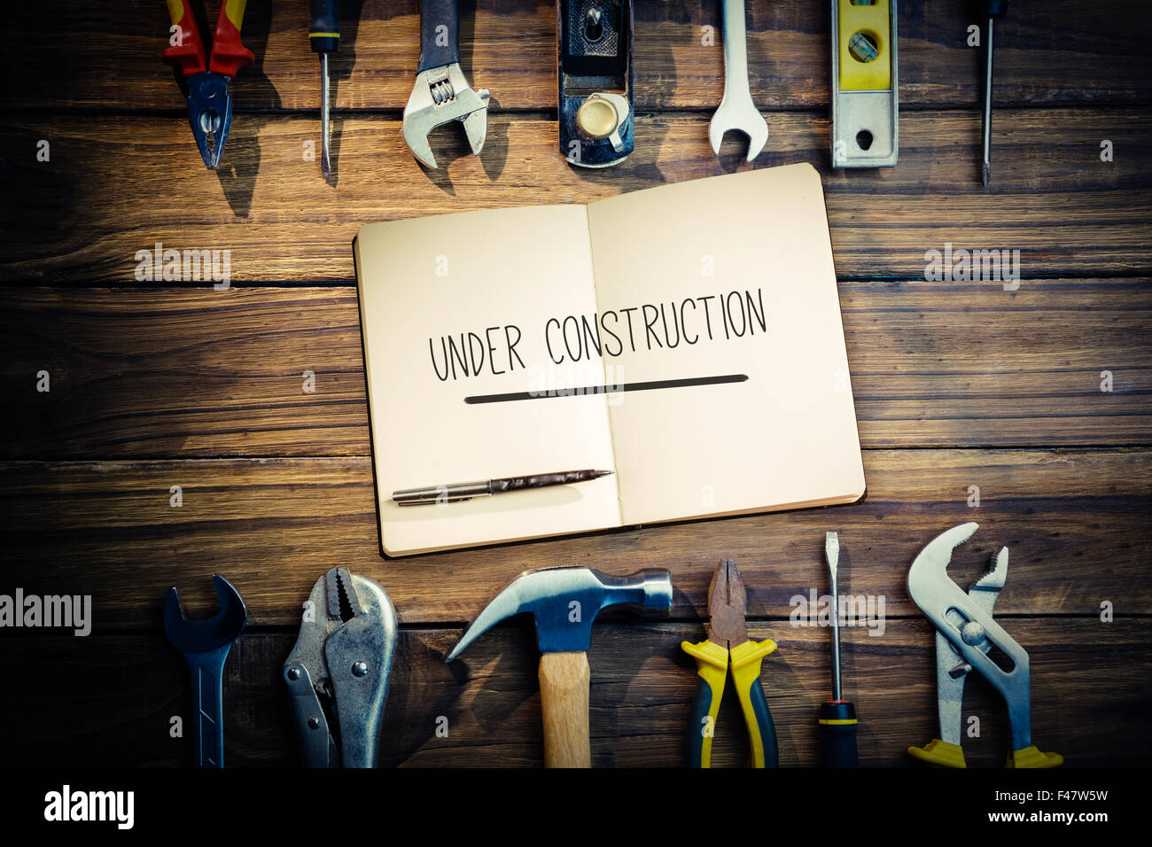 Under construction against desk with tools Stock Photo - Alamy