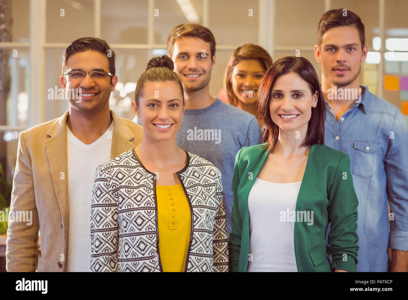 Happy business team smiling at camera Stock Photo - Alamy